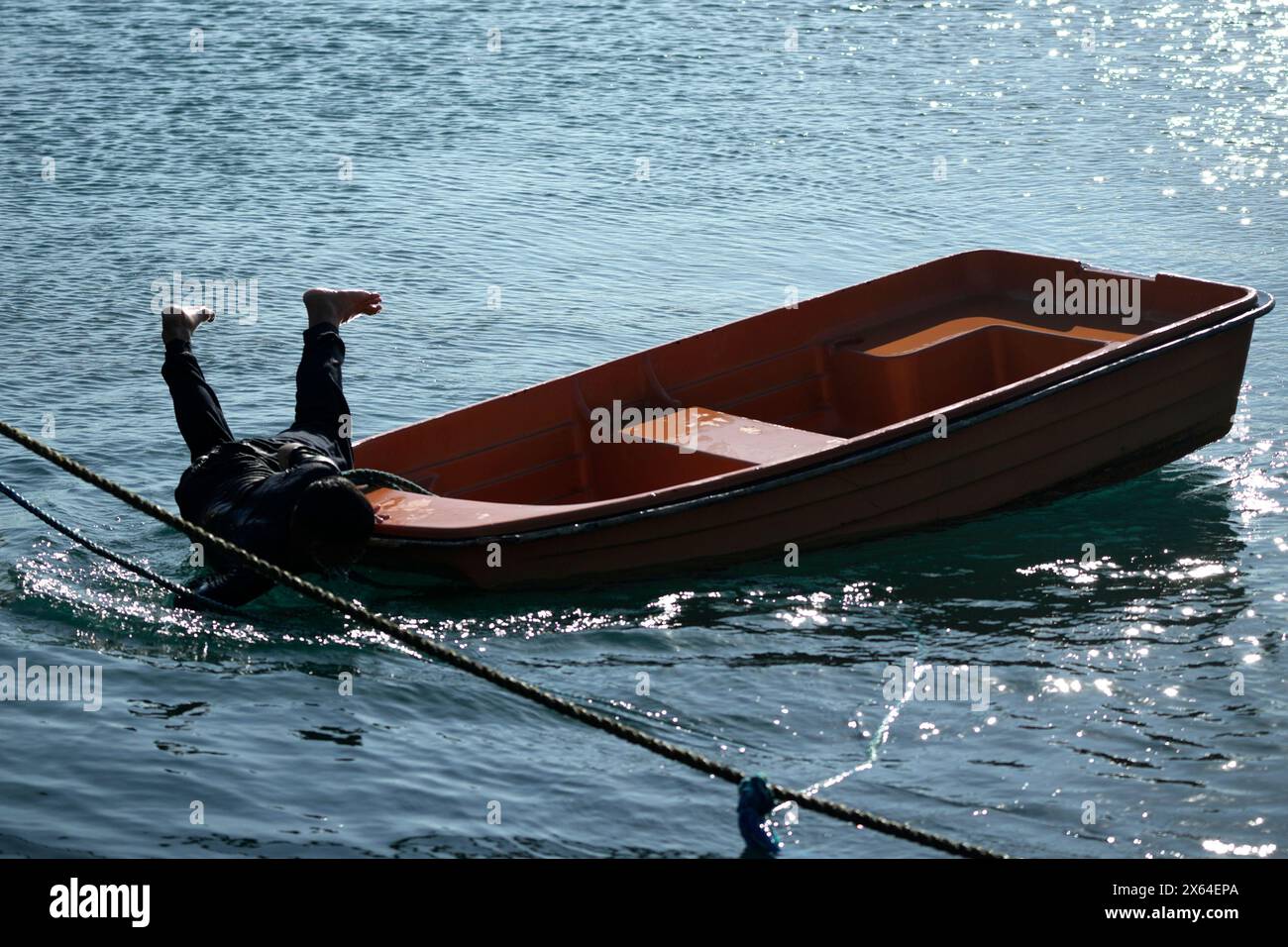 A boy jumps off his boat at the port of the coastal town of Santa Ana ...