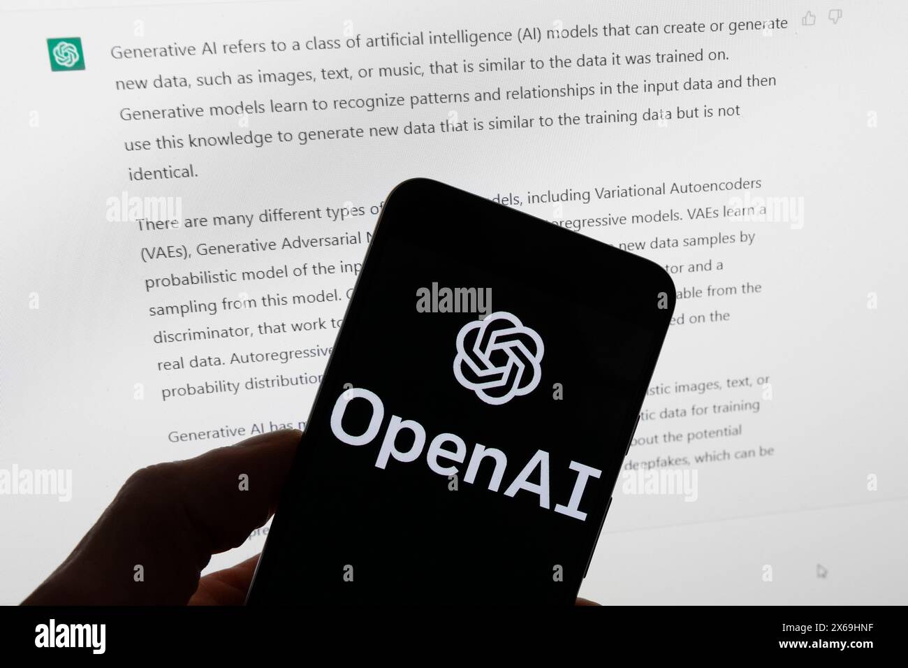 FILE - The OpenAI logo is seen on a mobile phone in front of a computer screen displaying output ...