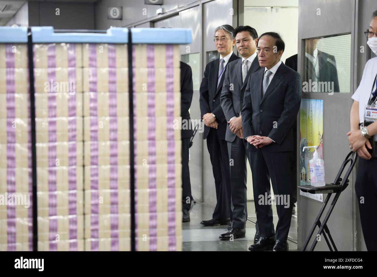 Bank of Japan's governor Kazuo Ueda (R) watch new banknotes, issued for ...