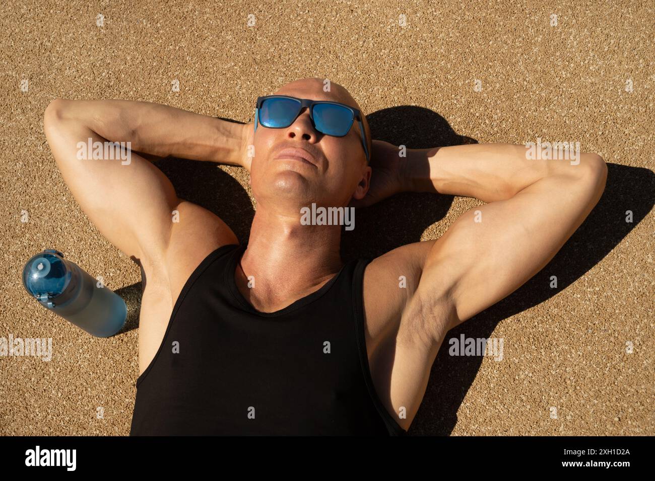 Athlètes homme dans des lunettes de soleil et bouteille d'eau couchée ...