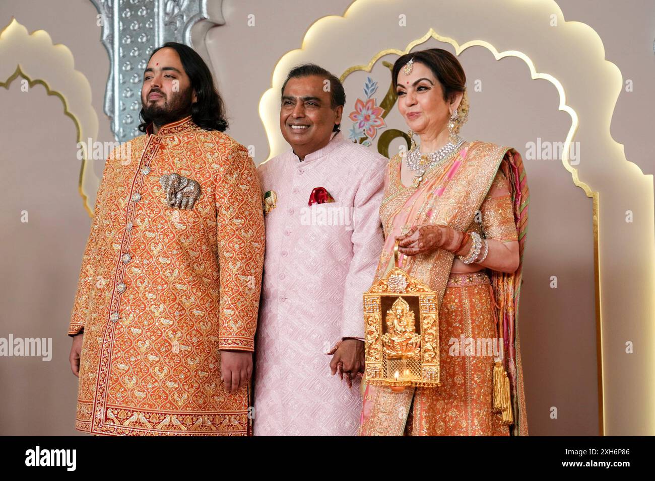 Billionaire Mukesh Ambani, center, poses with son Anant, and wife Nita ...