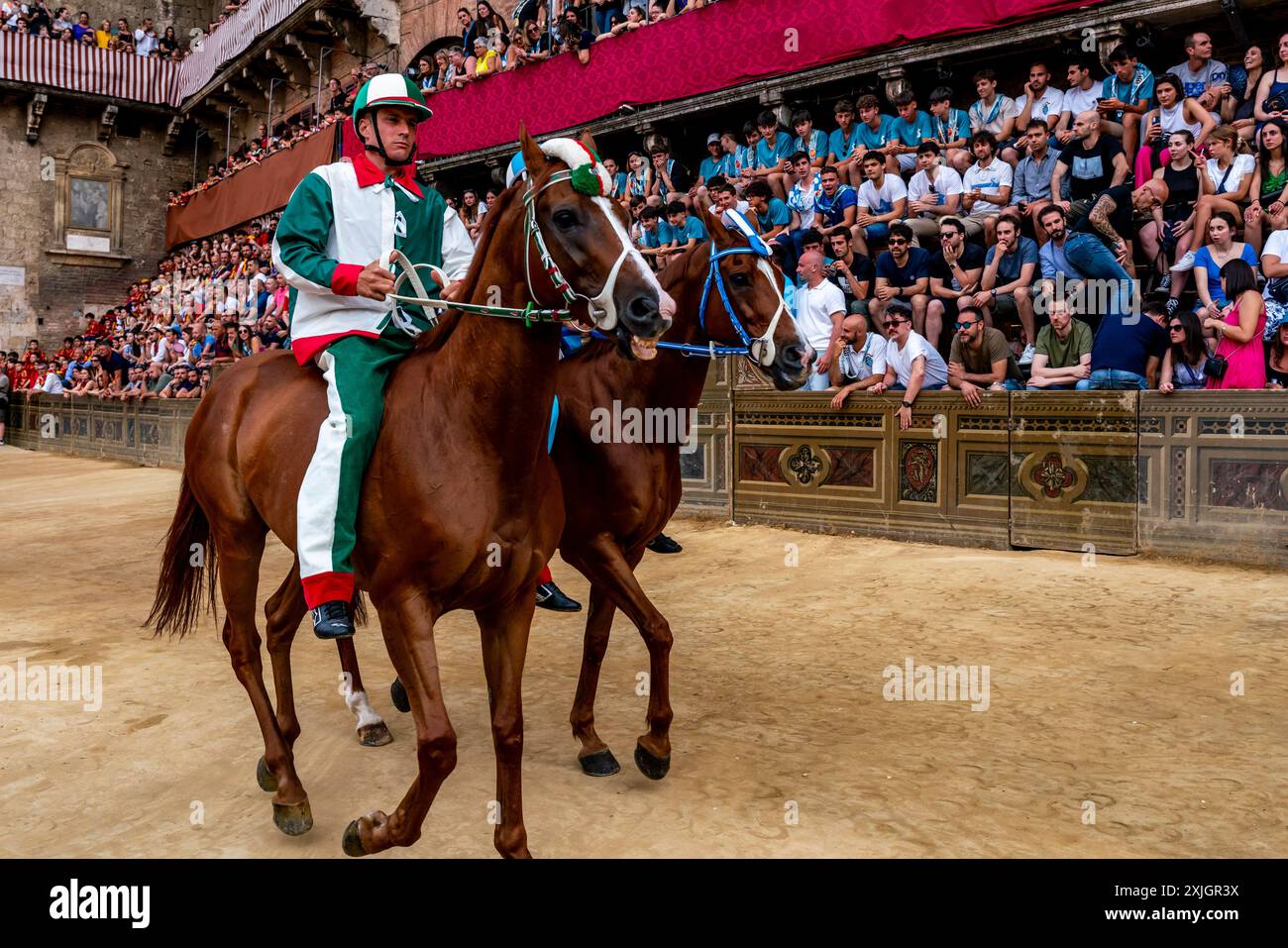 Les jockeys portant leurs couleurs Contrada approchent de la ligne de ...