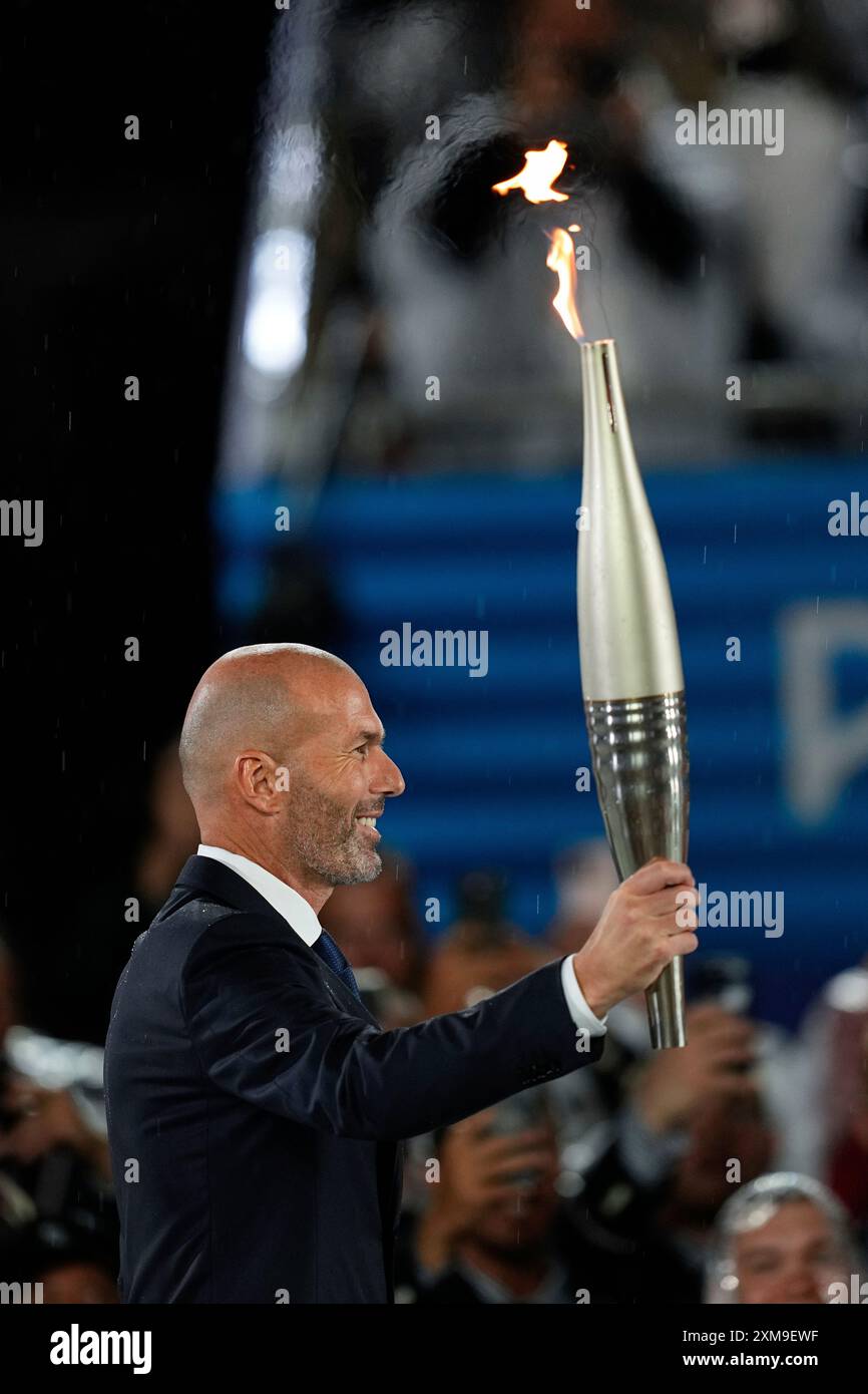 Zinedine Zidane carries the olympic torch during the opening ceremony ...