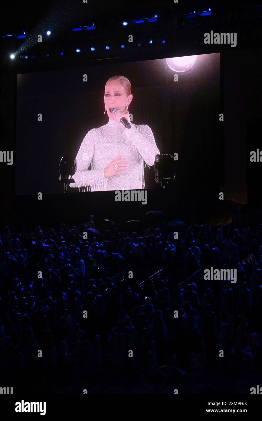 Canadian Singer Celine Dion performs on the Eiffel Tower on the screen ...