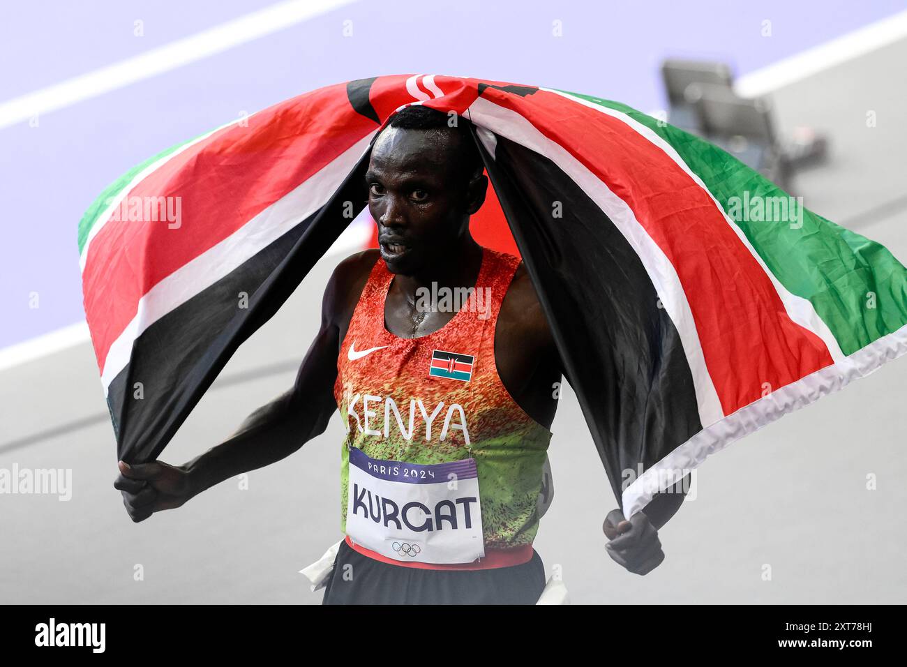 Edwin Kurgat du Kenya tient un drapeau national après avoir participé à ...