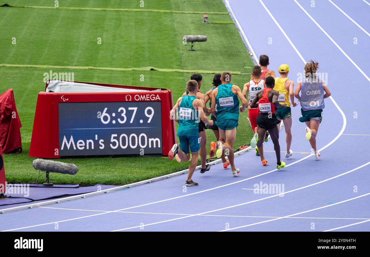 Les athlètes paralympiques qui courent le 5000 mètres masculin courent ...