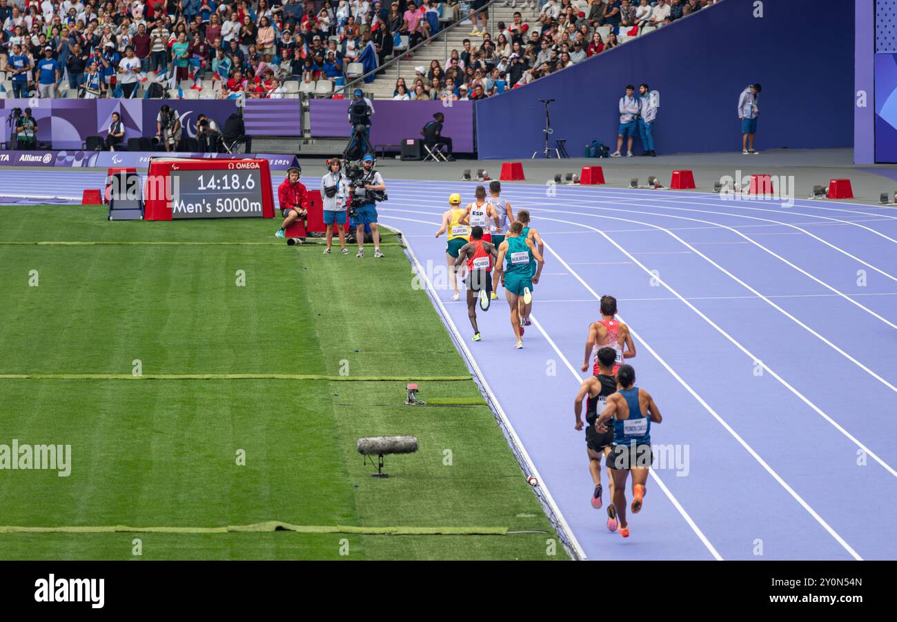 Les athlètes paralympiques qui courent le 5000 mètres masculin courent ...