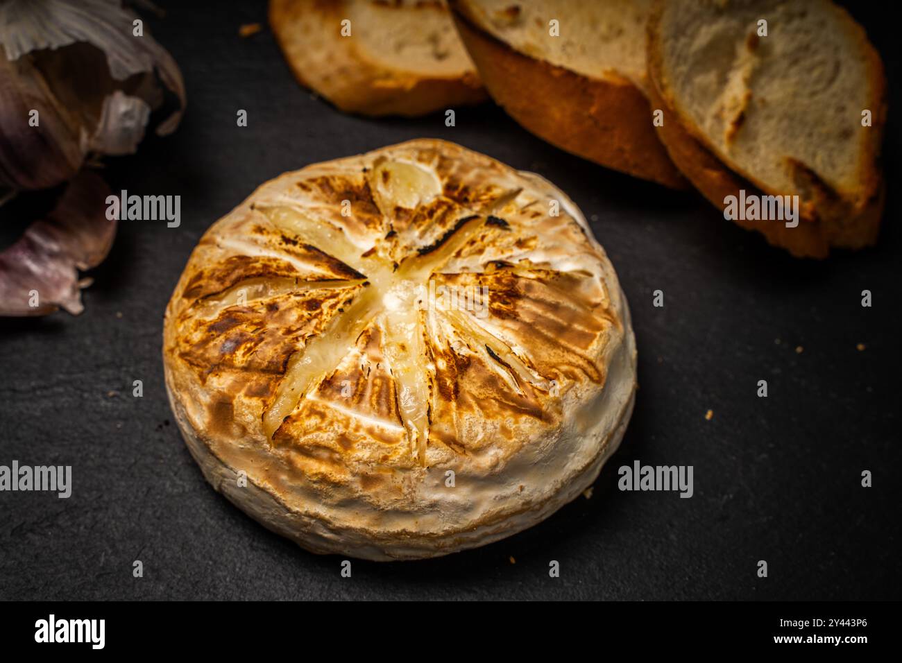 Brie ou camembert cuit au four sur fond noir avec du pain grillé ou des ...