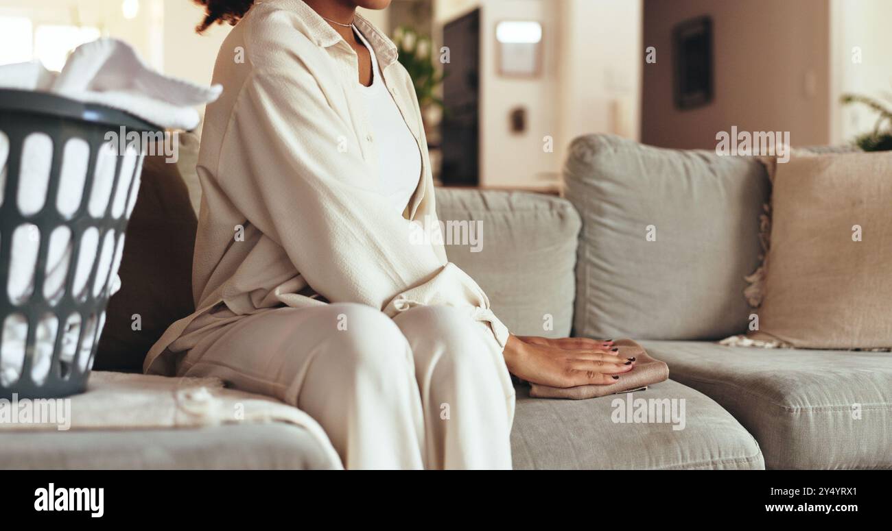 Mains, lessive et plier les vêtements sur le canapé avec du linge frais ...