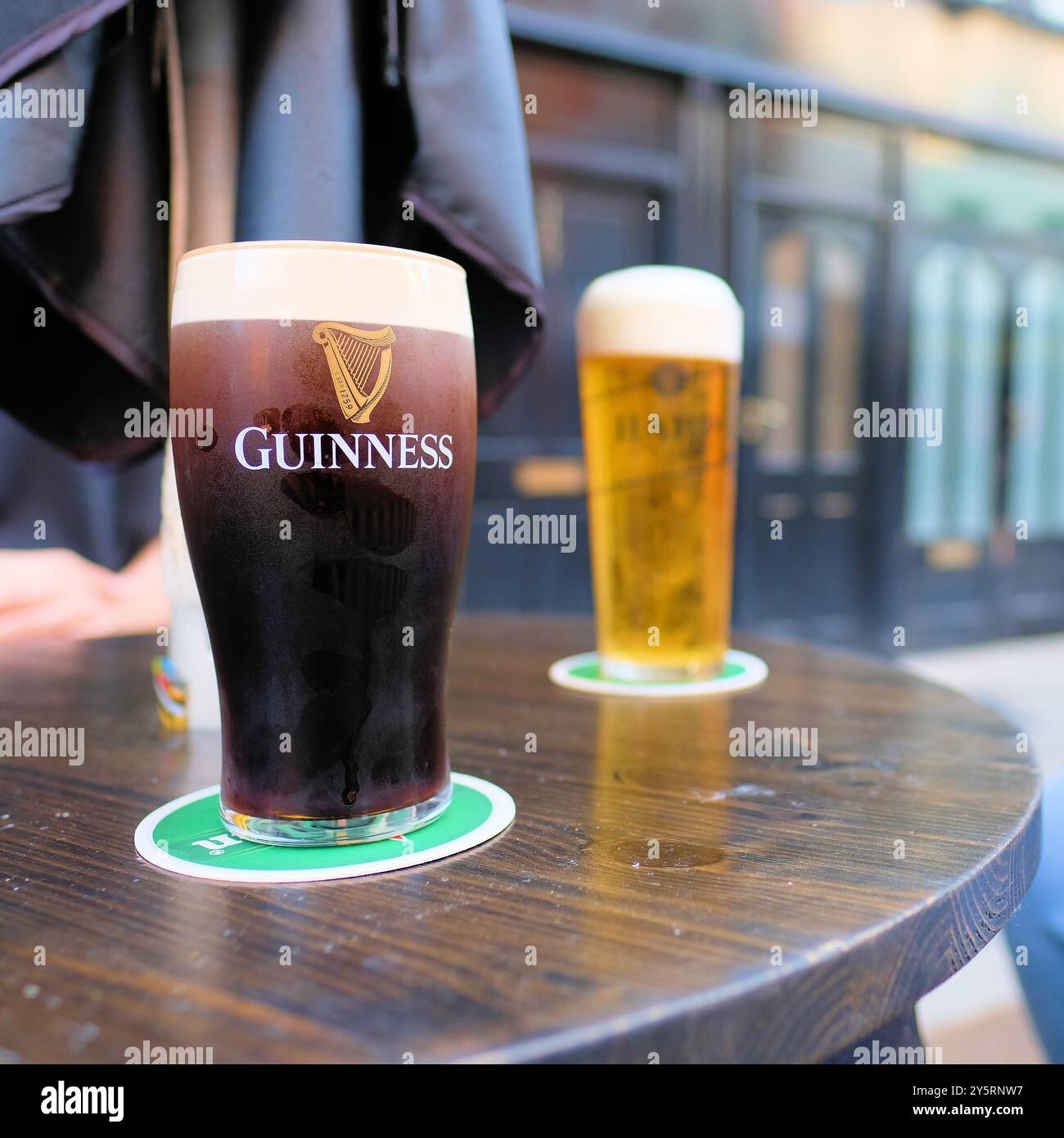 Un verre de marque de bière Guinness stout avec une tête de mousse ...