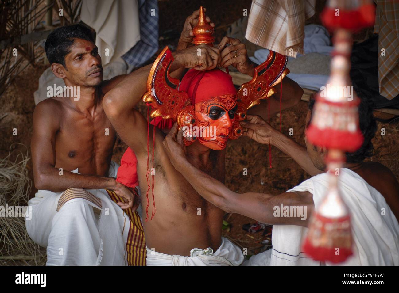 Artiste Theyyam avec visage peint, lors de la préparation d'un rituel ...