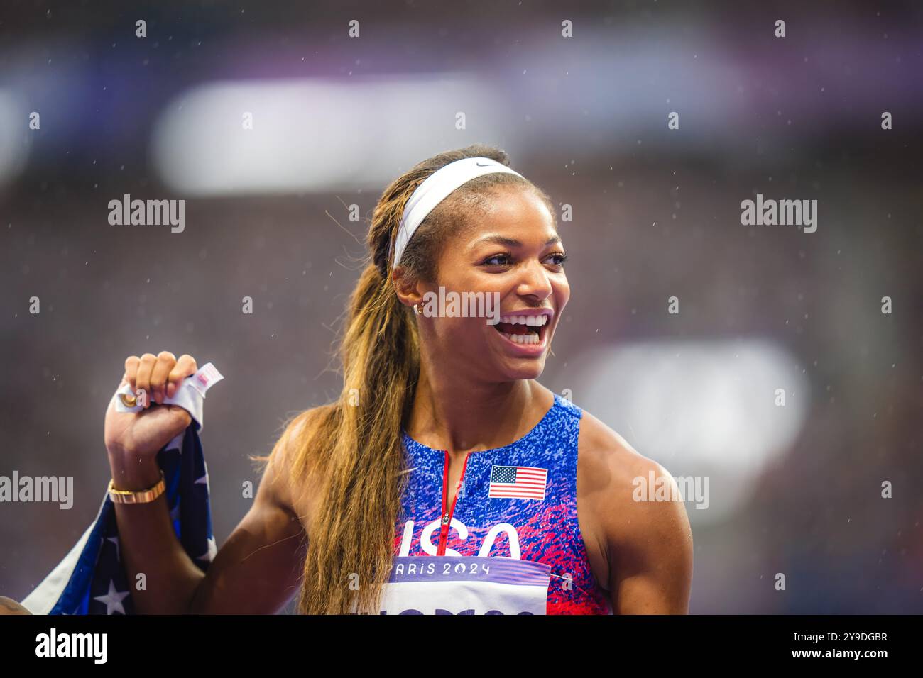 Gabrielle Thomas célébrant avec le drapeau de son pays dans le relais ...