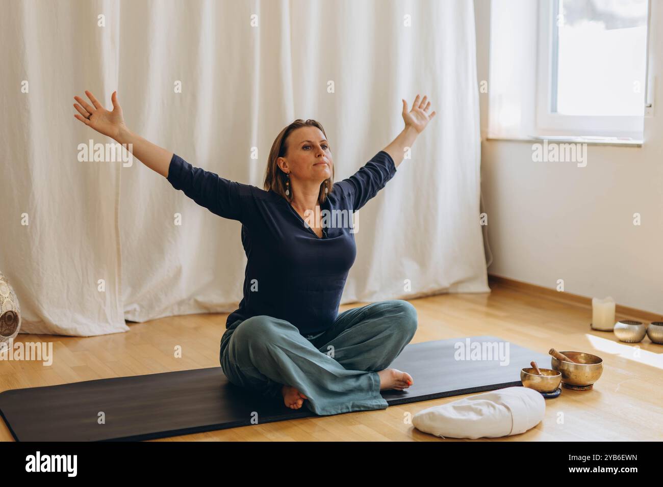 Une femme est assise sur le sol les yeux fermés, pratiquant des ...