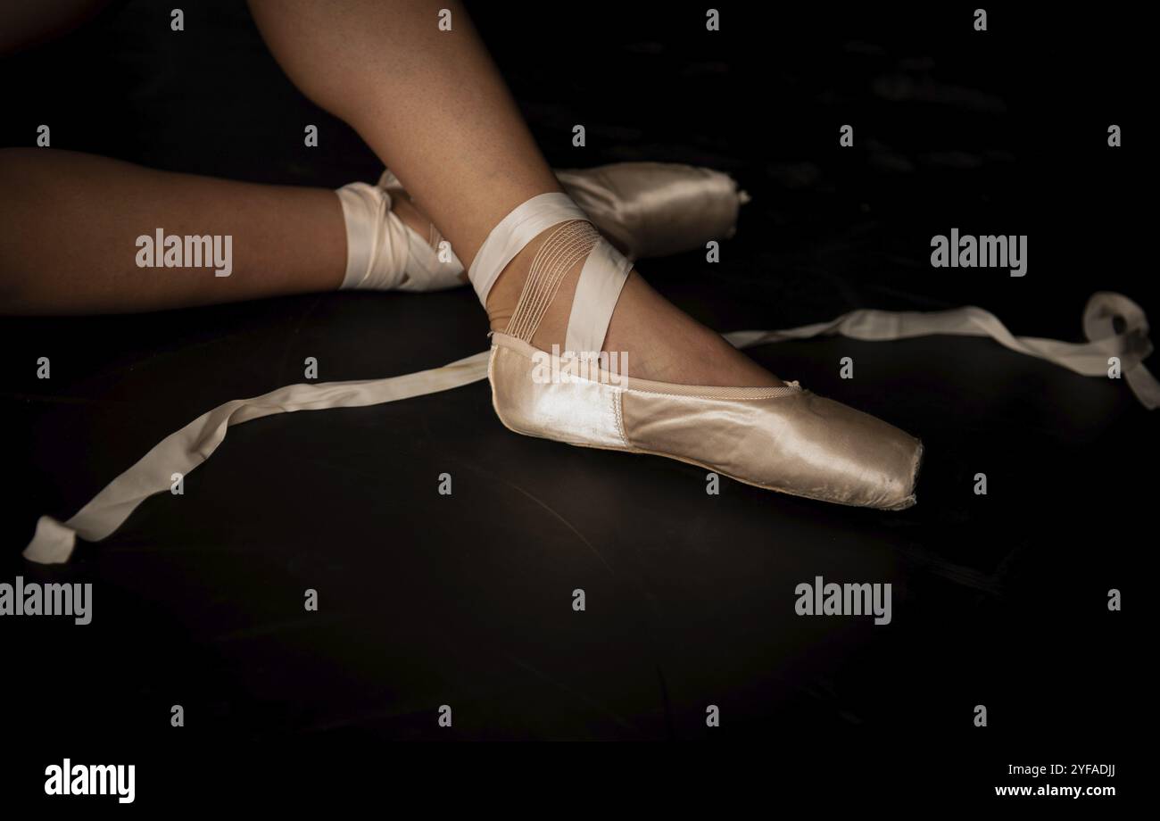 Belles jambes de la jeune ballerine qui met des chaussures pointe au ...