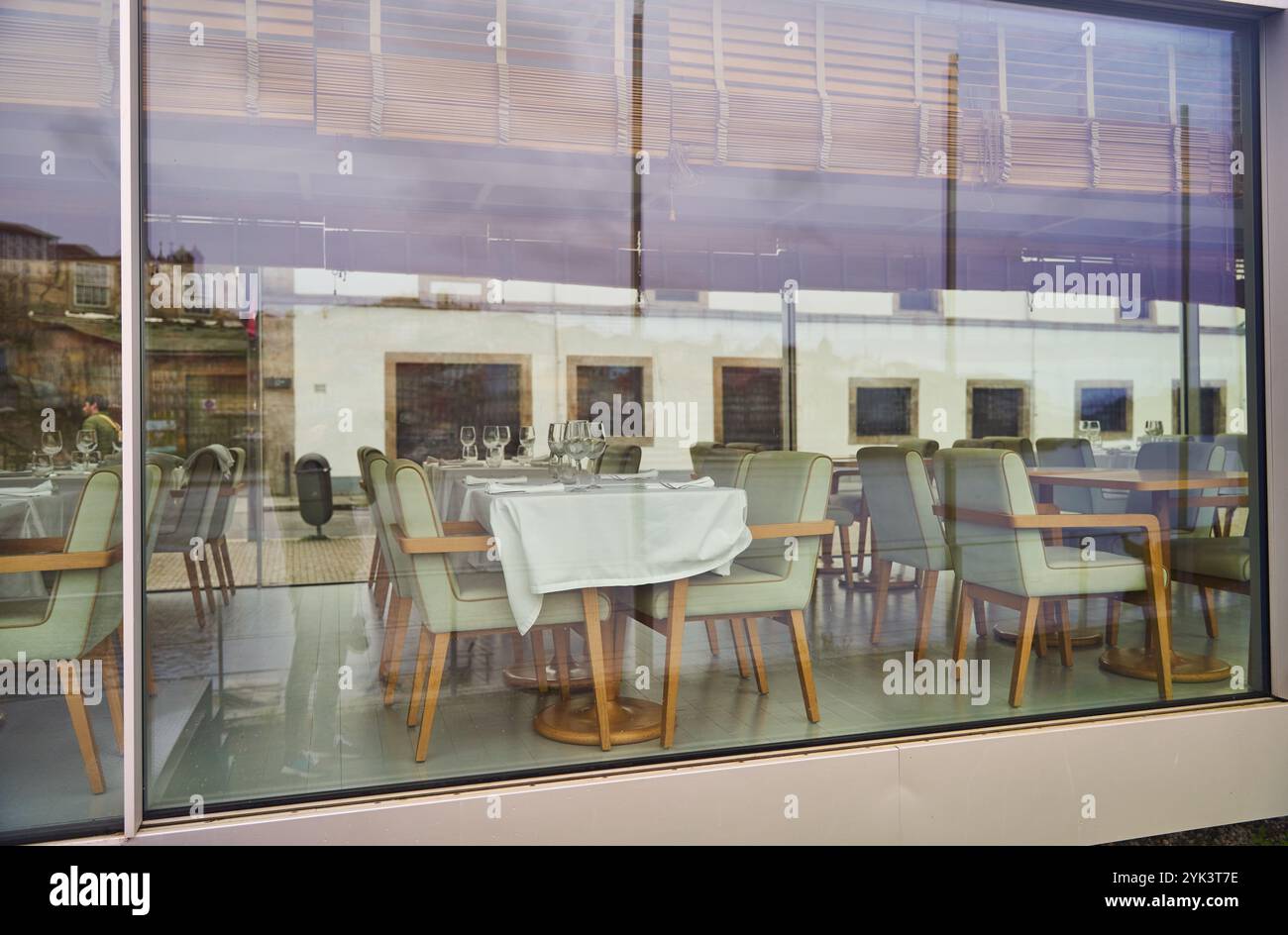 La façade du bâtiment reflète les tables et les chaises des restaurants ...