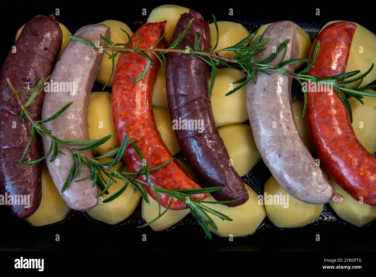 Saucisses crues au four. Gros plan du bol avec saucisse de sang maison crue, saucisse de porc et ...