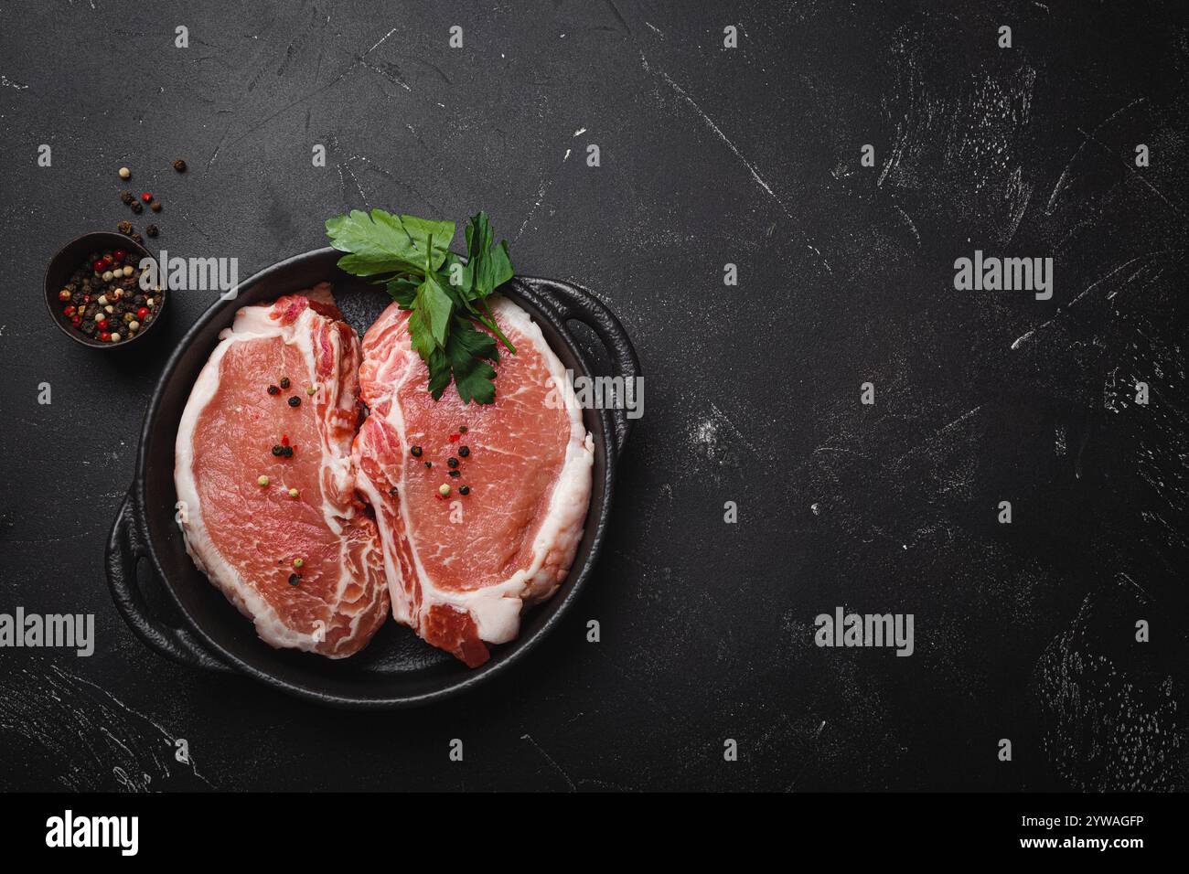 Coupez les steaks de porc de viande crue avec assaisonnements dans une ...