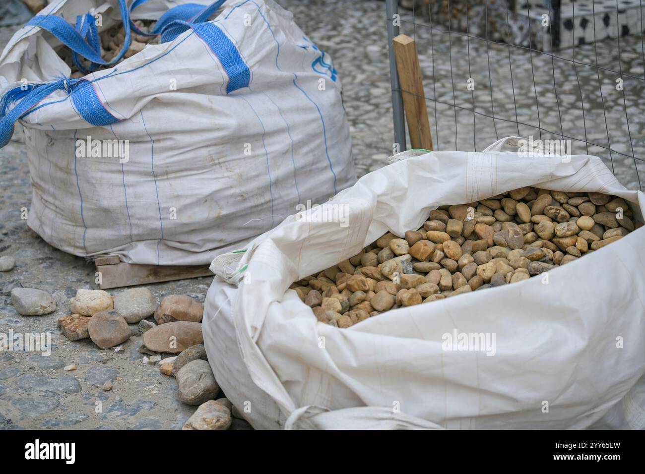 Les sacs blancs de pierres concassées sont dans une rangée, matériau de ...