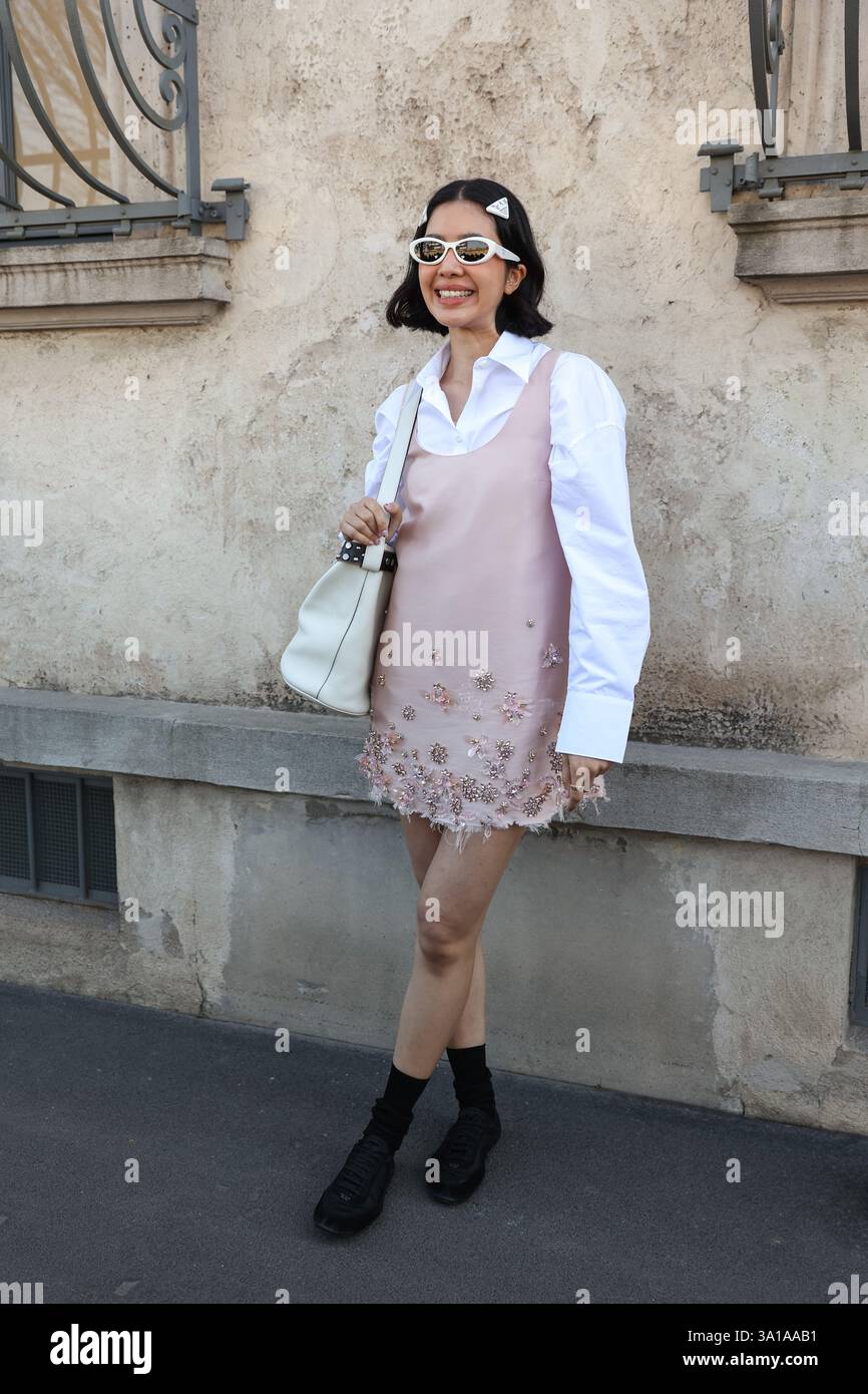 Une fashionista pose pour des photos avant le défilé Prada FW 2025 / ...