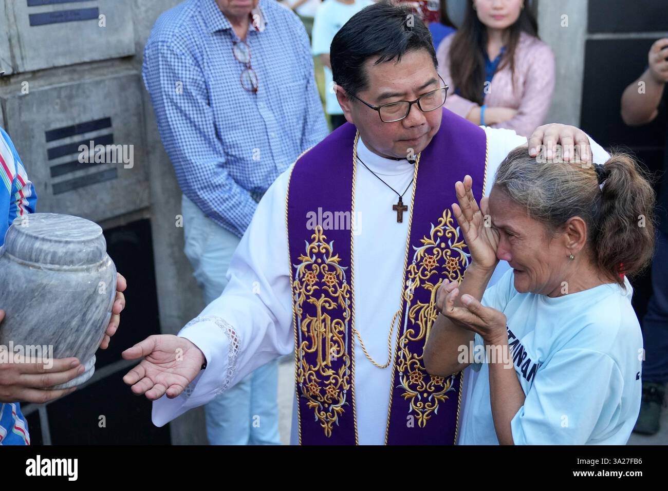 Filipino Catholic priest Flavie Villanueva, left, consoles Melinda ...