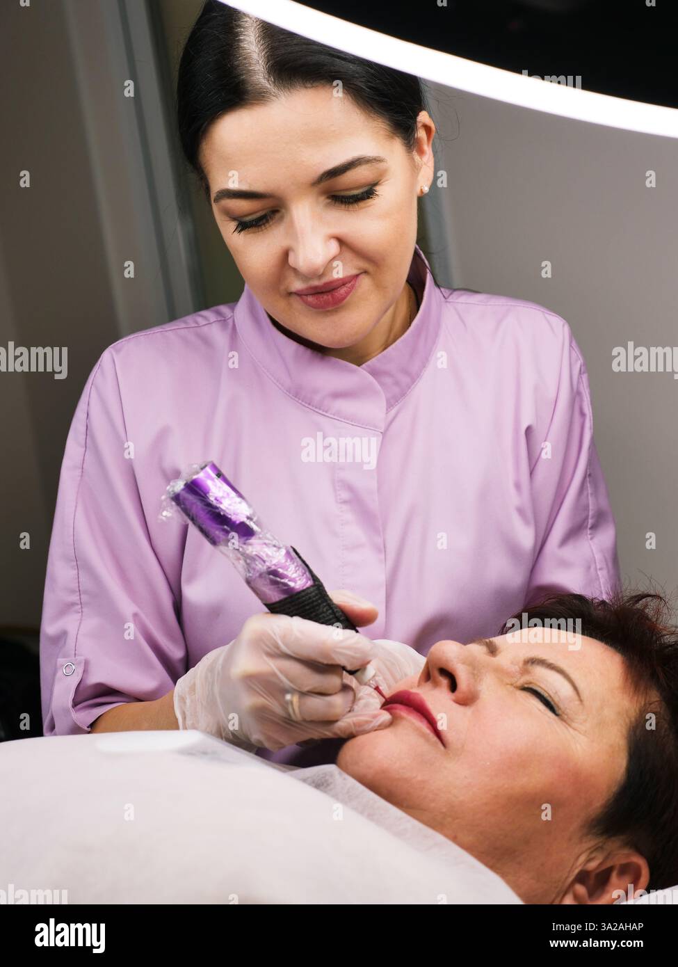 Maquilleuse permanente tatoue une belle femme de plus de 50 ans dans un ...