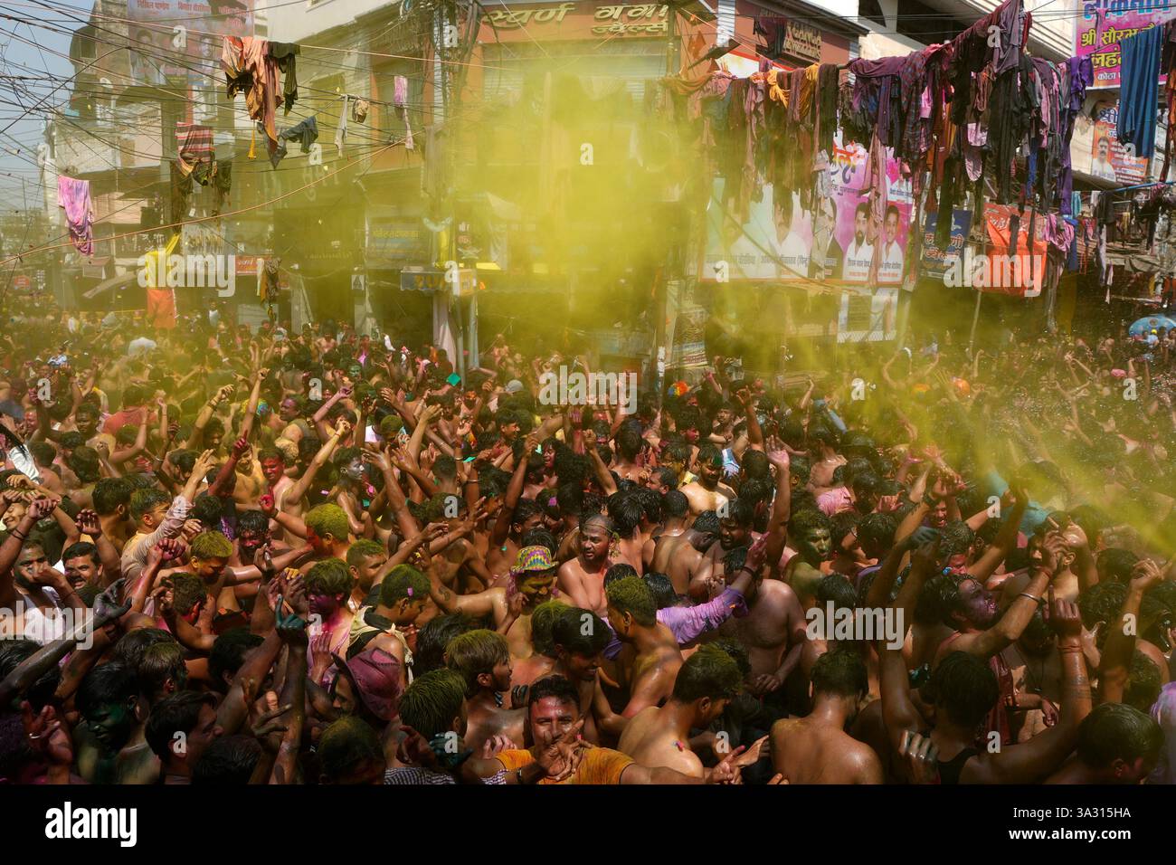 Indian revelers, faces smeared with colored powder, dance during ...