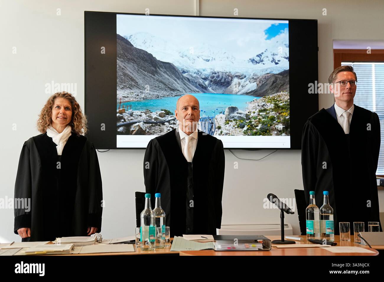 Judge Rolf Meyer, center, stands in front of a glacier picture in the ...