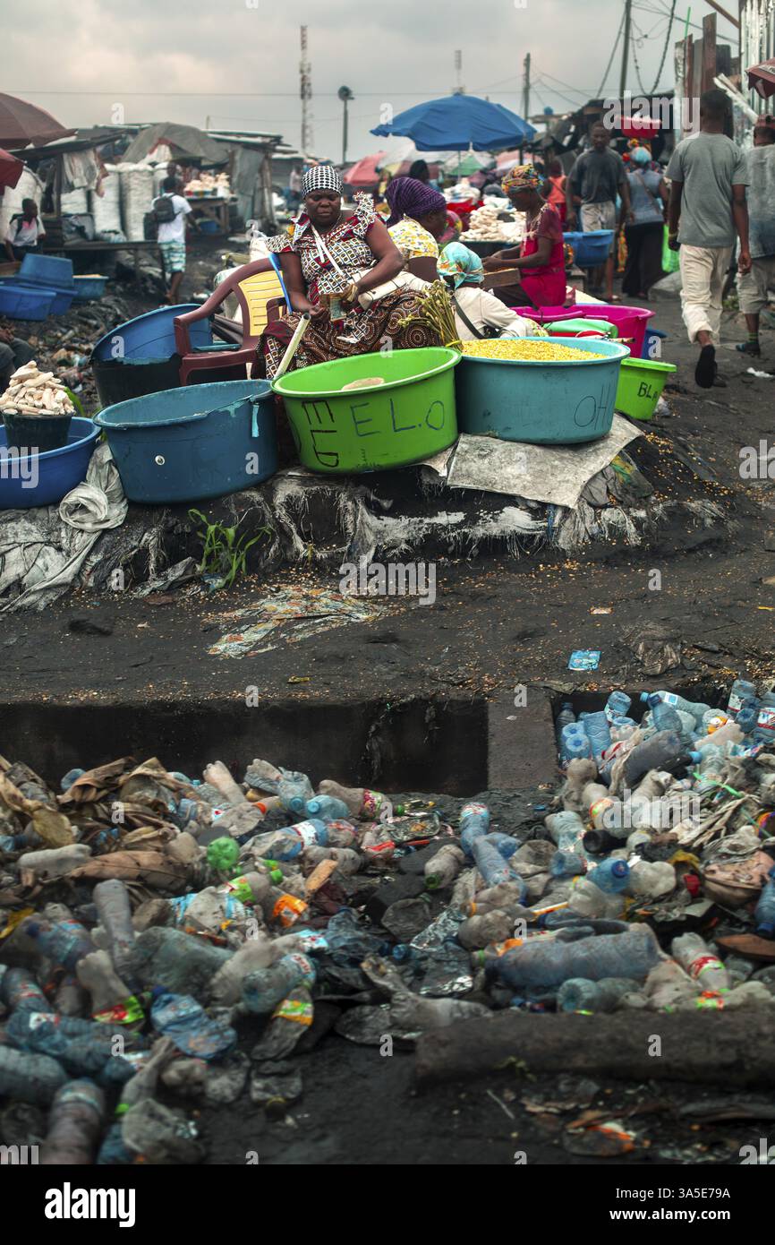 Femme de marché entourée de déchets plastiques, pollution de l ...