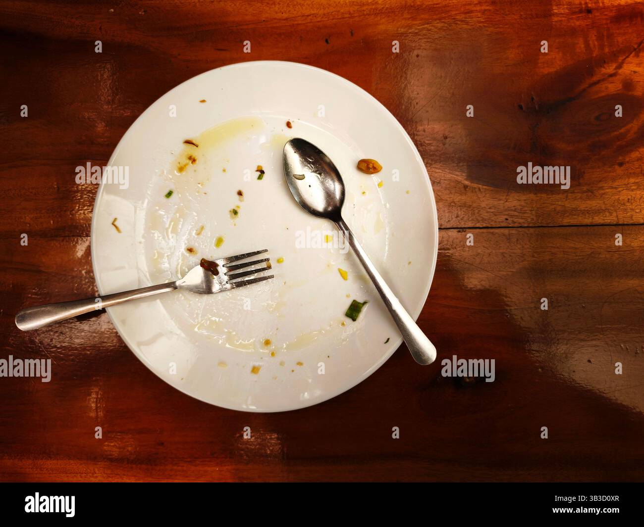 Assiette blanche avec cuillère et fourchette après utilisation pour ...