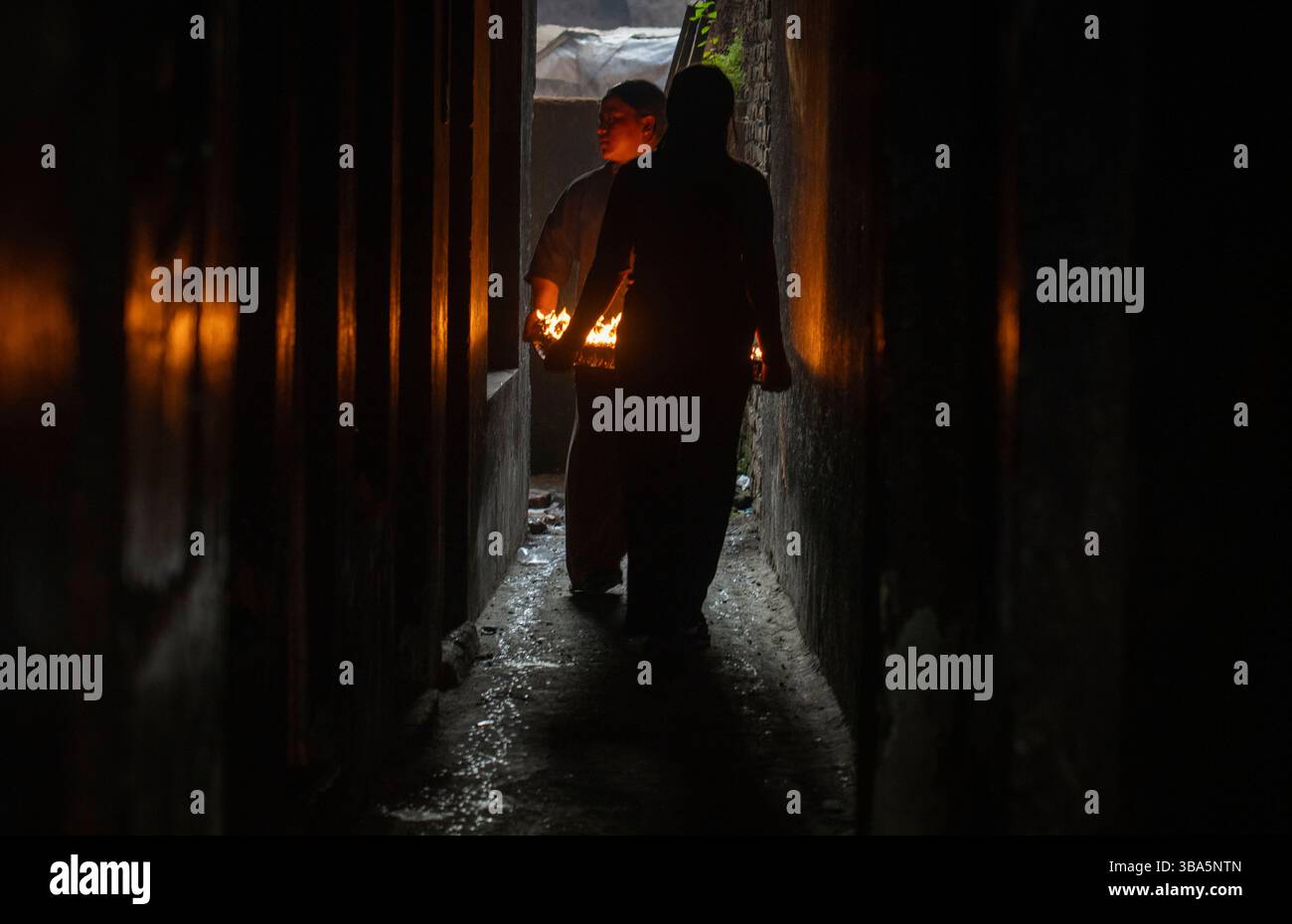 Nepalese vendors carry new butter lamps to sell to devotees during Buddha Jayanti or Buddha ...