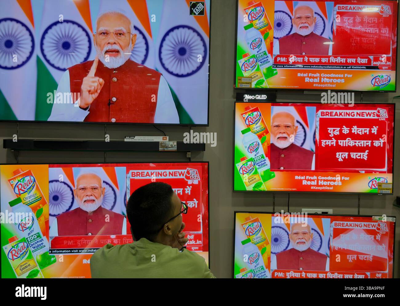 An Indian man watches the live telecast of Indian Prime Minister ...