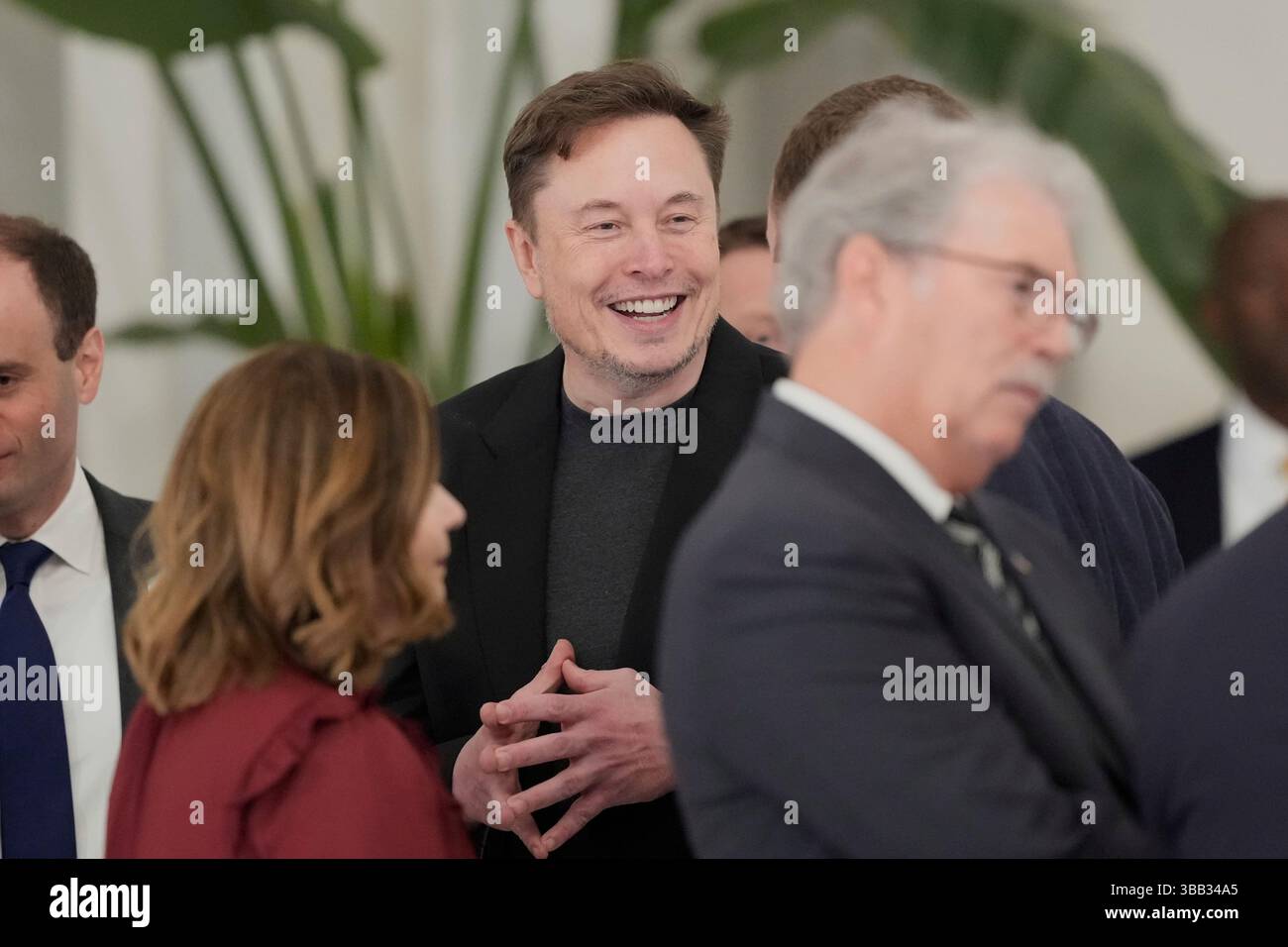 Elon Musk gestures as he arrives for a state dinner hosted by Qatar's ...