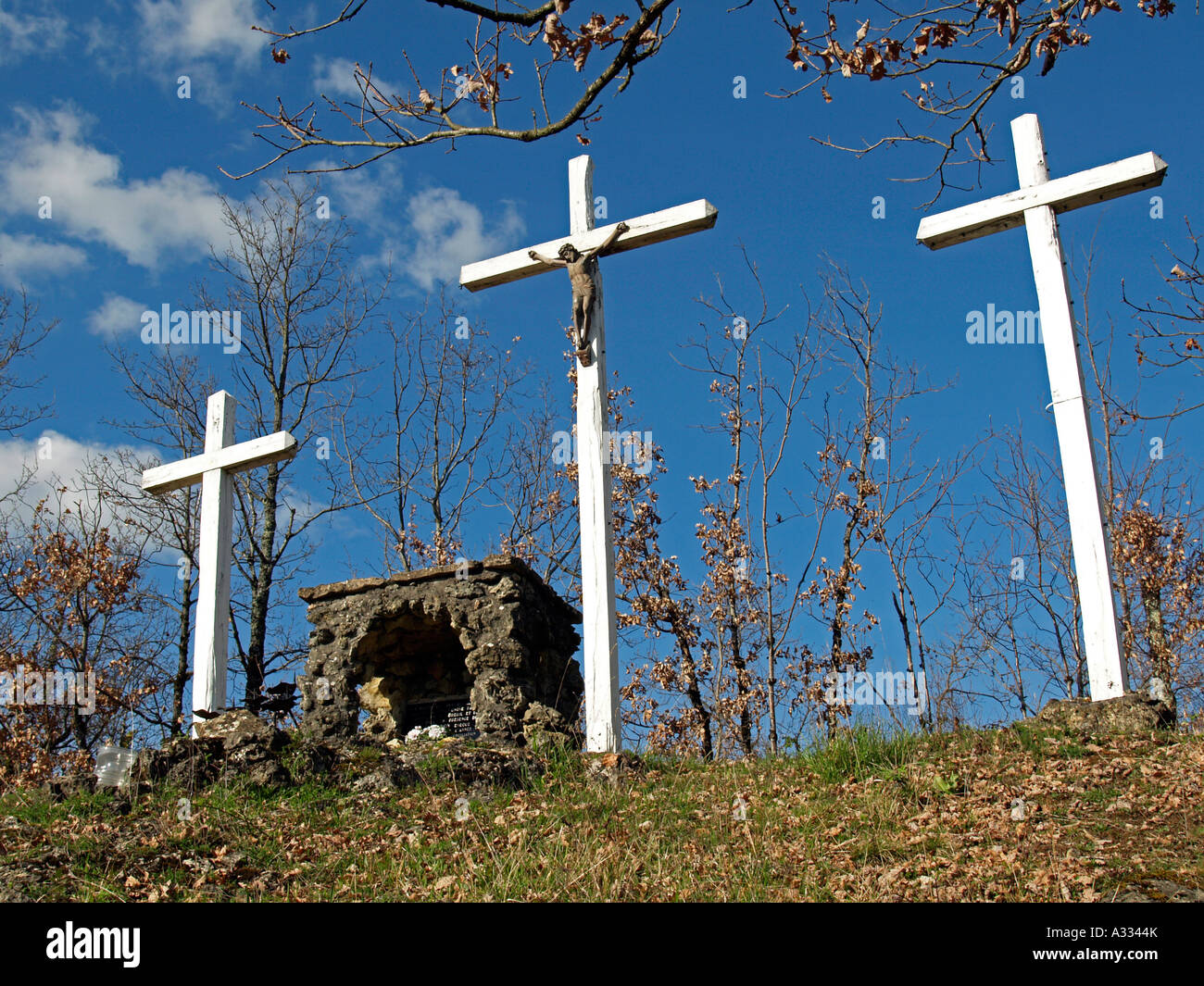 Trois croix avec un crucifix sur une colline en face de ciel bleu sur ...