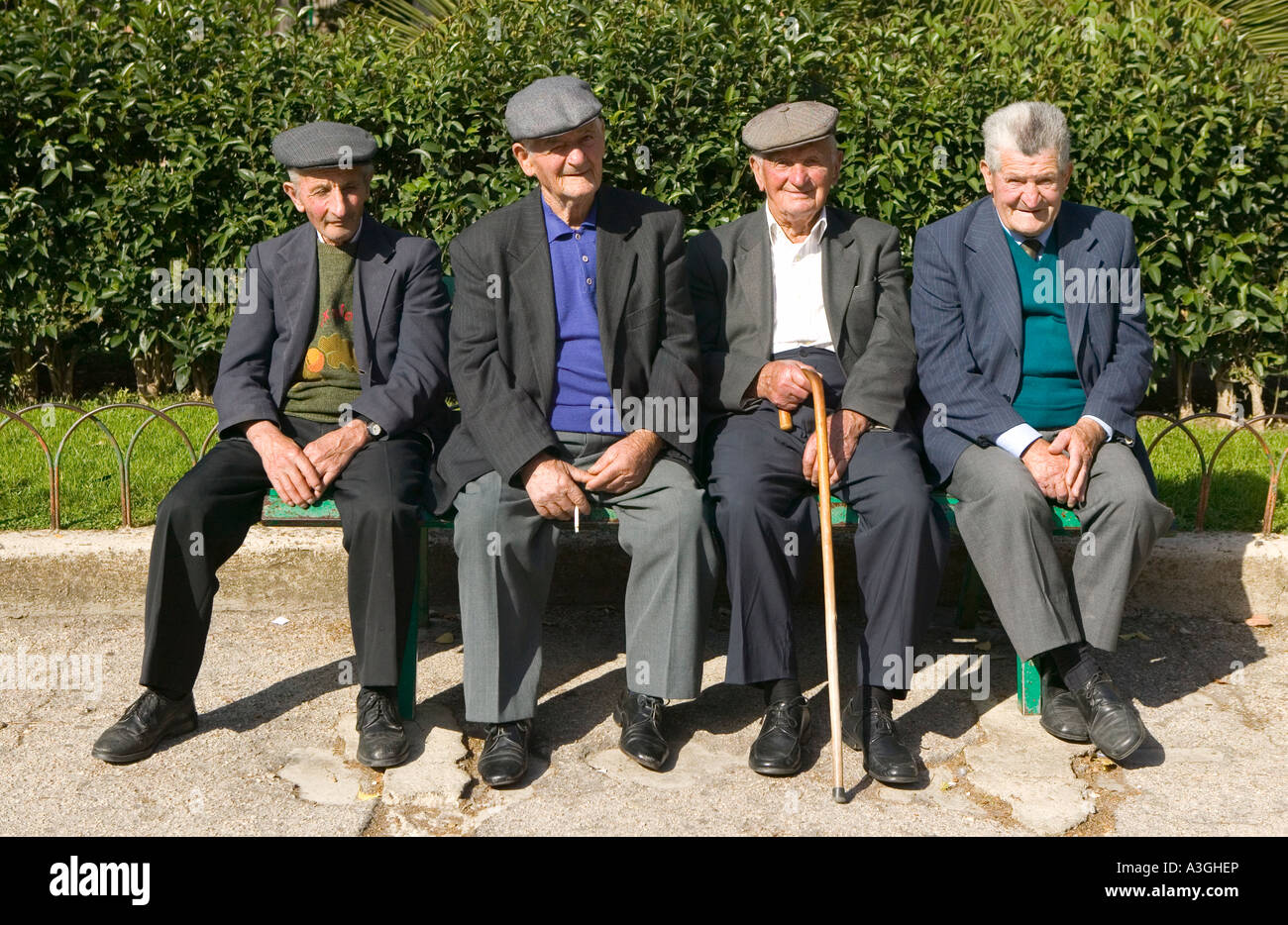 Un groupe de vieillards sur un banc de parc dans les Pouilles, Italie ...