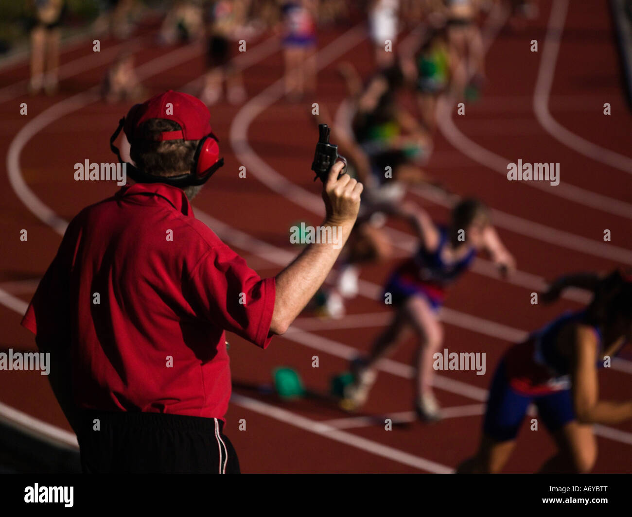 Commissaire de course tenant un pistolet de départ au début d'une piste ...