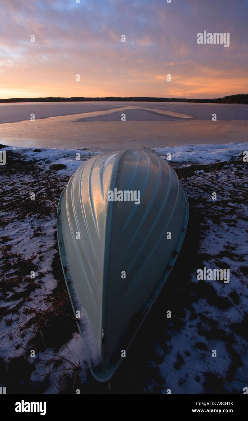 Bateau à rame, pif ou canot, enraché à l'envers sur le bord du lac à ...