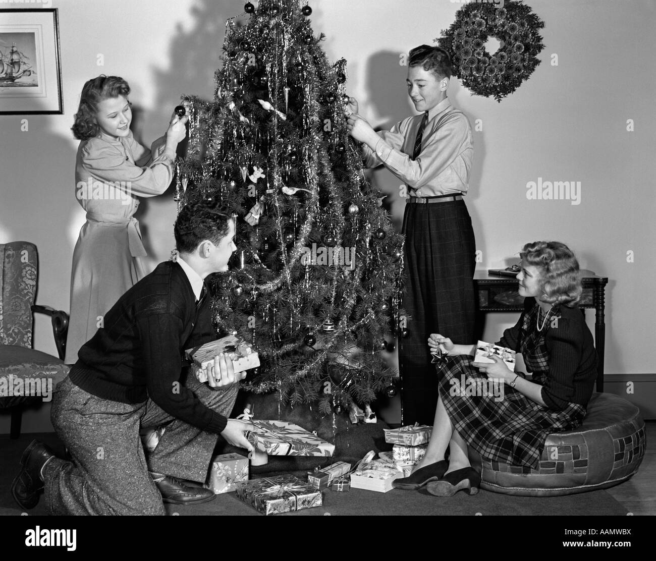 1930 1940 4 adolescents DECORATING CHRISTMAS TREE METTANT WRAPPED GIFTS ...