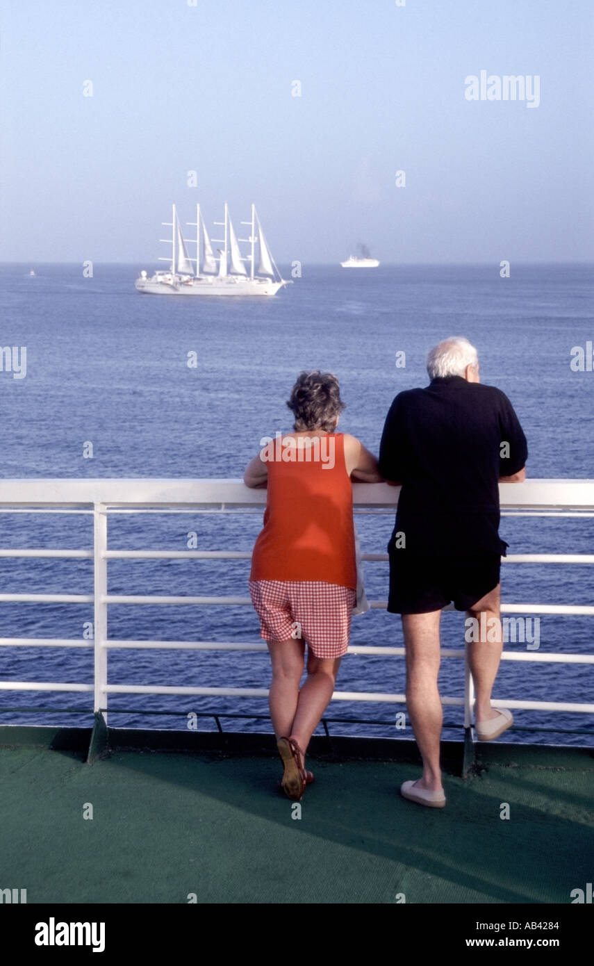 Deux passagers à bord d'un bateau de croisière observant quatre bateaux ...