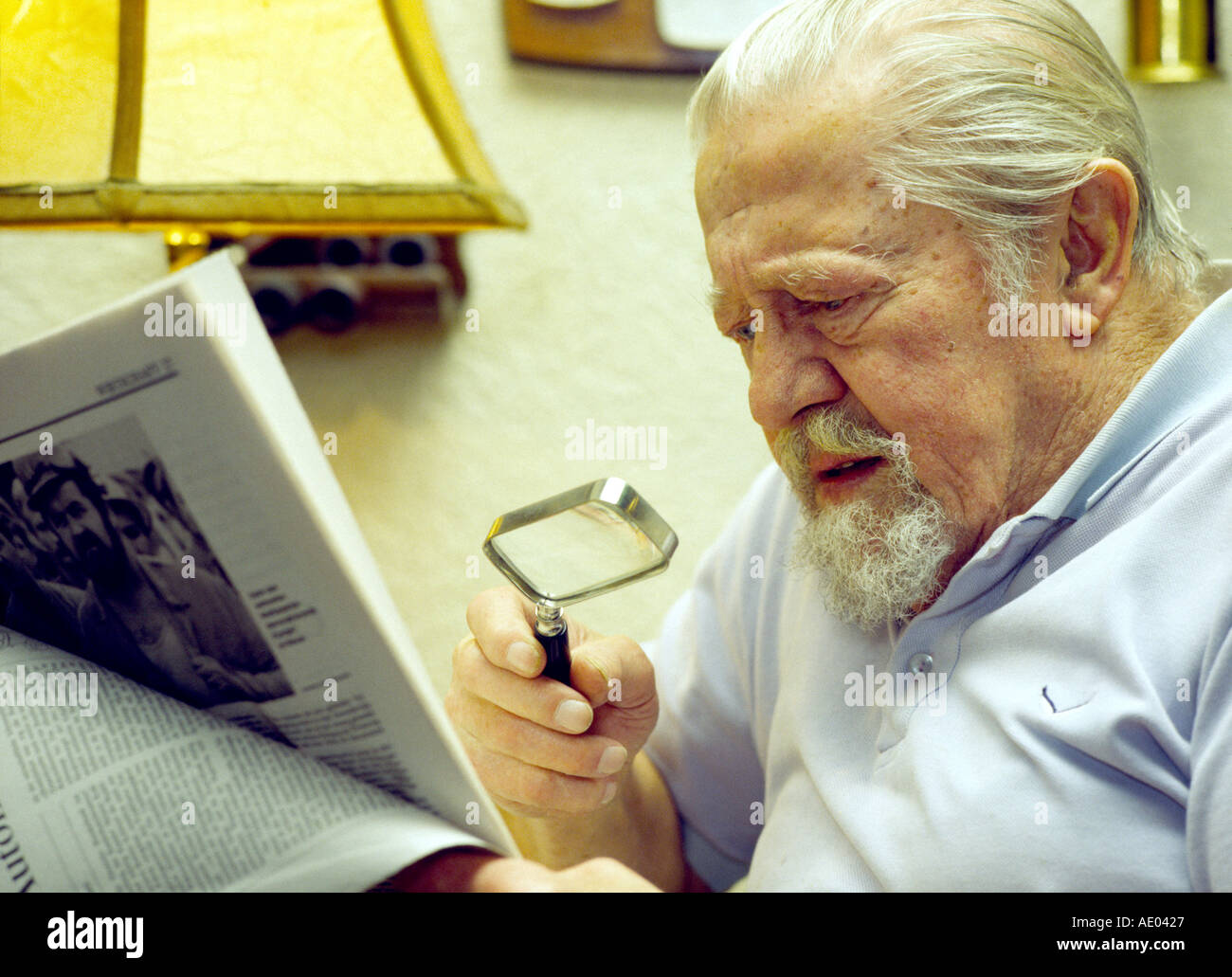 Old Man reading newspaper with magnifying glass Photo Stock - Alamy