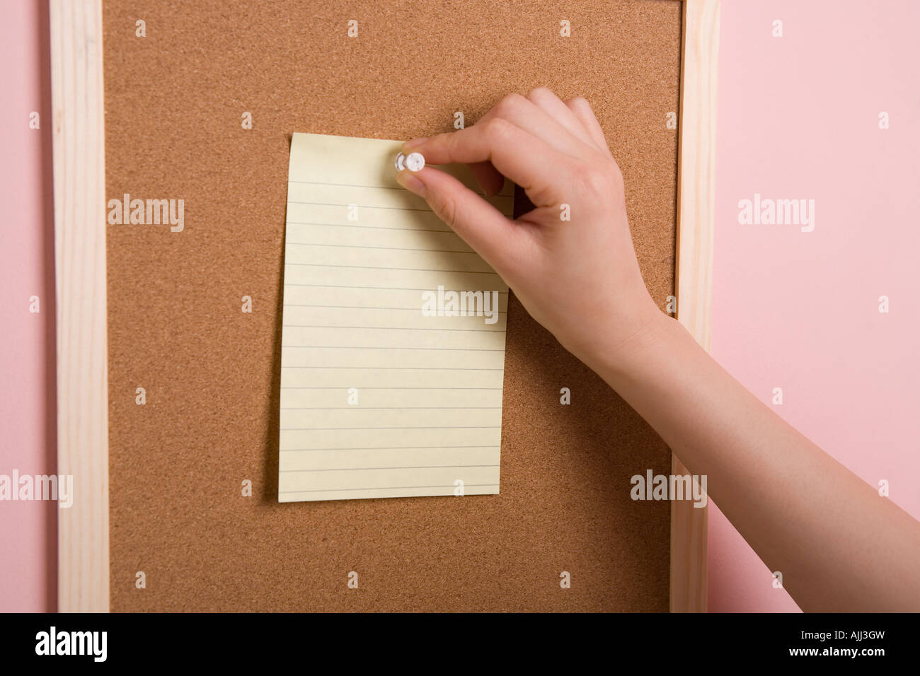 Woman's hand pinning note de bulletin board Photo Stock - Alamy