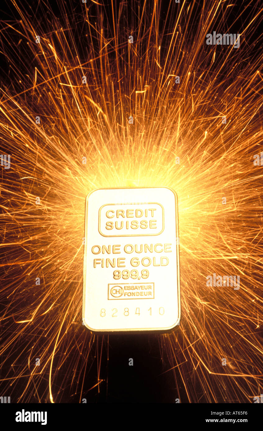 La barre d'une once d'or fin avec des étincelles provenant de derrière ...