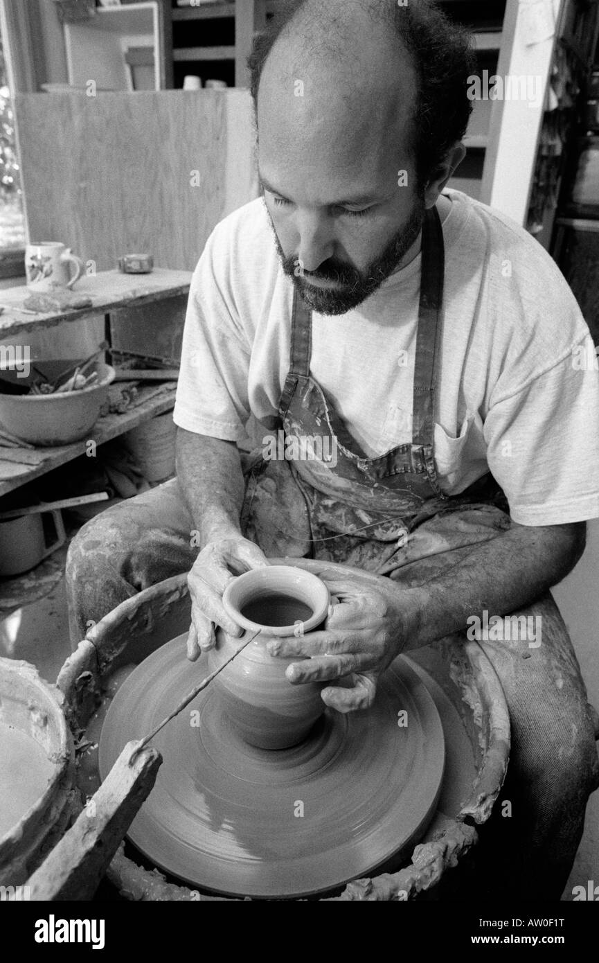 Un potier travaille jeter des pots de céramique dans son studio près de ...