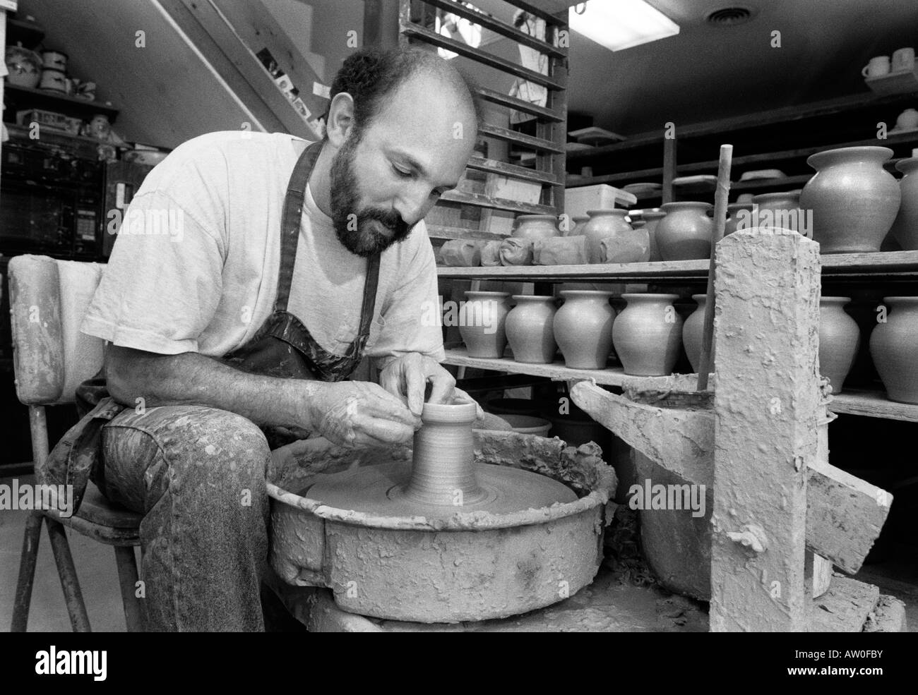 Un potier travaille jeter des pots de céramique dans son studio près de ...