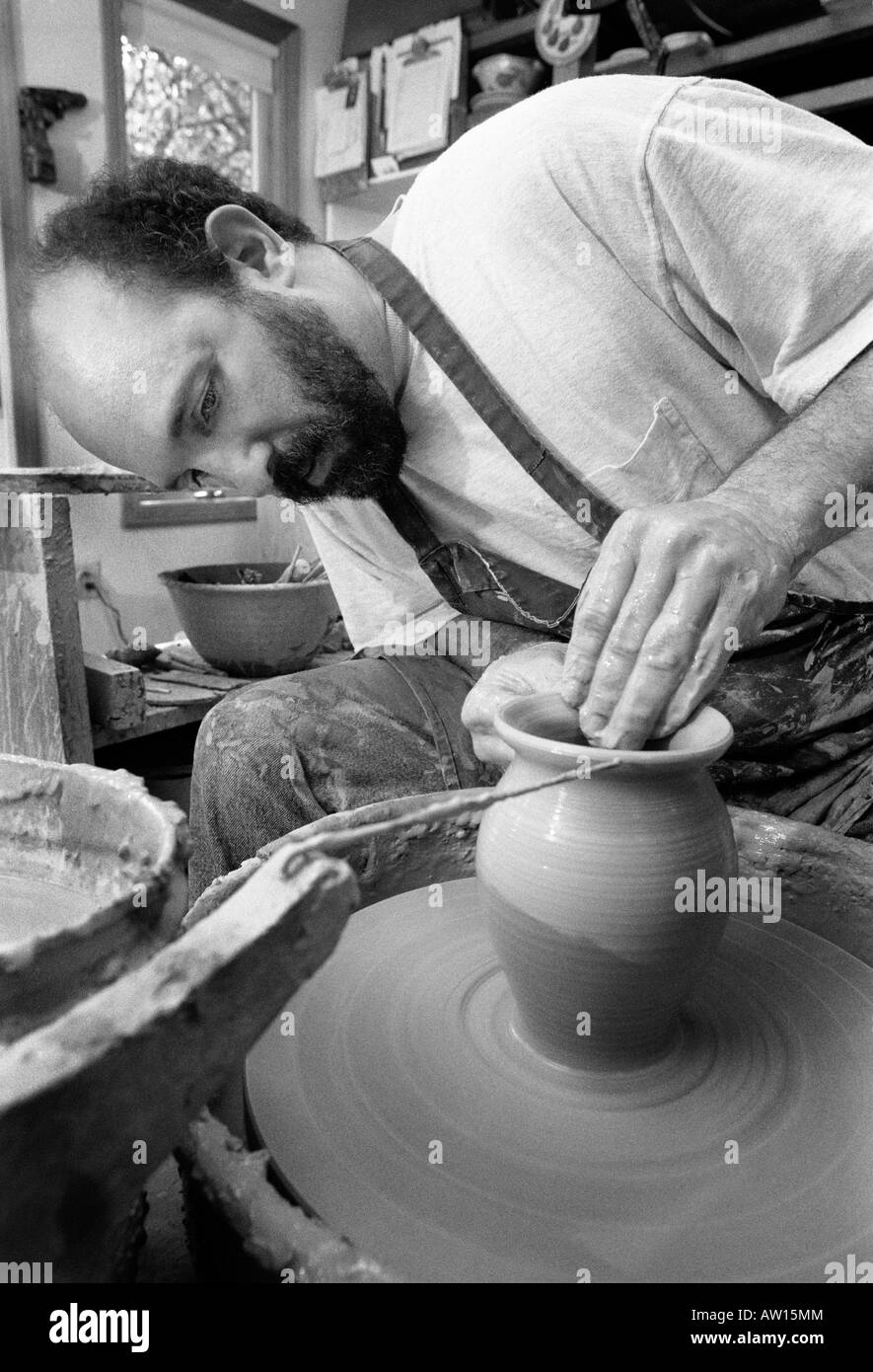 Un potier travaille jeter des pots de céramique dans son studio près de ...