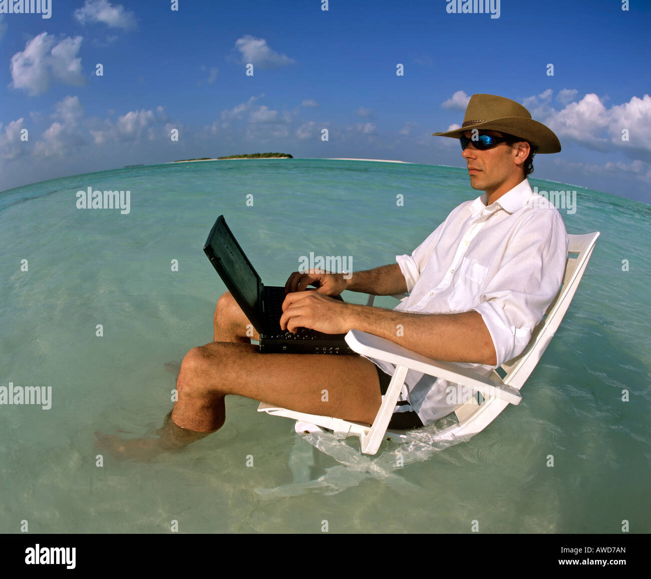 Jeune homme avec portable assis sur une chaise, travail et détente ...