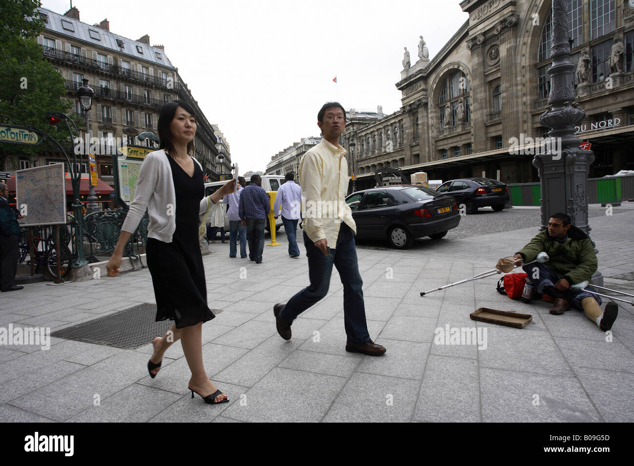 Un mendiant sur le trottoir et les gens qui marchent par, Paris, France ...