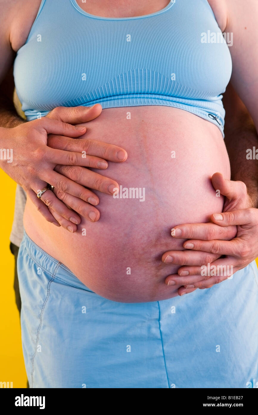 Vue Sur Le Ventre De Femme Enceinte Comme Mari Se Tient Derrière Elle Avec Ses Mains Liées Sur