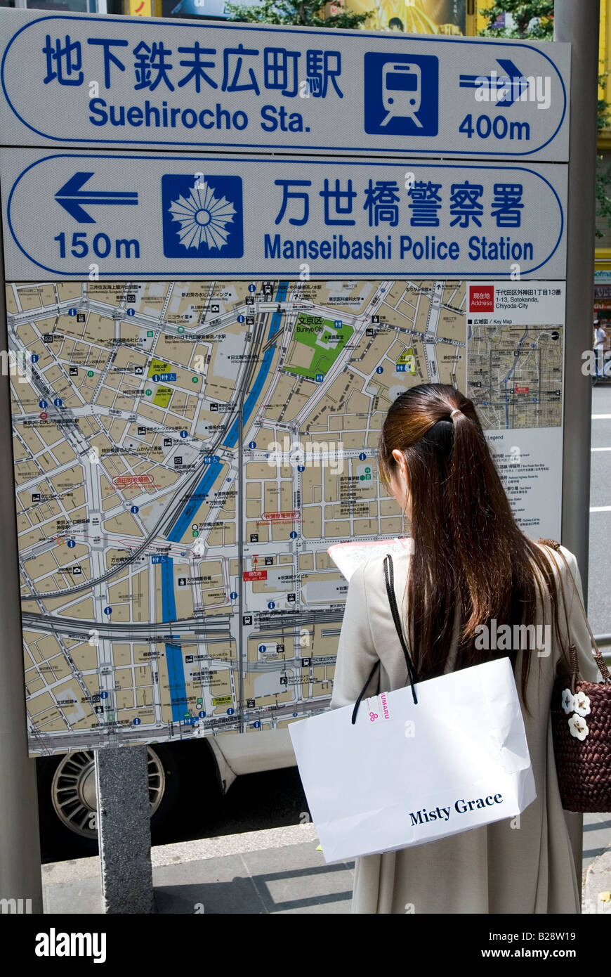 Une femme en regardant une carte du quartier Akihabara de Tokyo essaie ... Une femme en regardant une carte du quartier Akihabara de Tokyo essaie ...