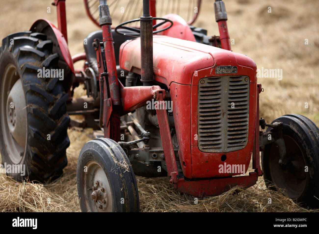 Vieux tracteur Massey Ferguson 35 avec pièce jointe haymaker assis dans ...