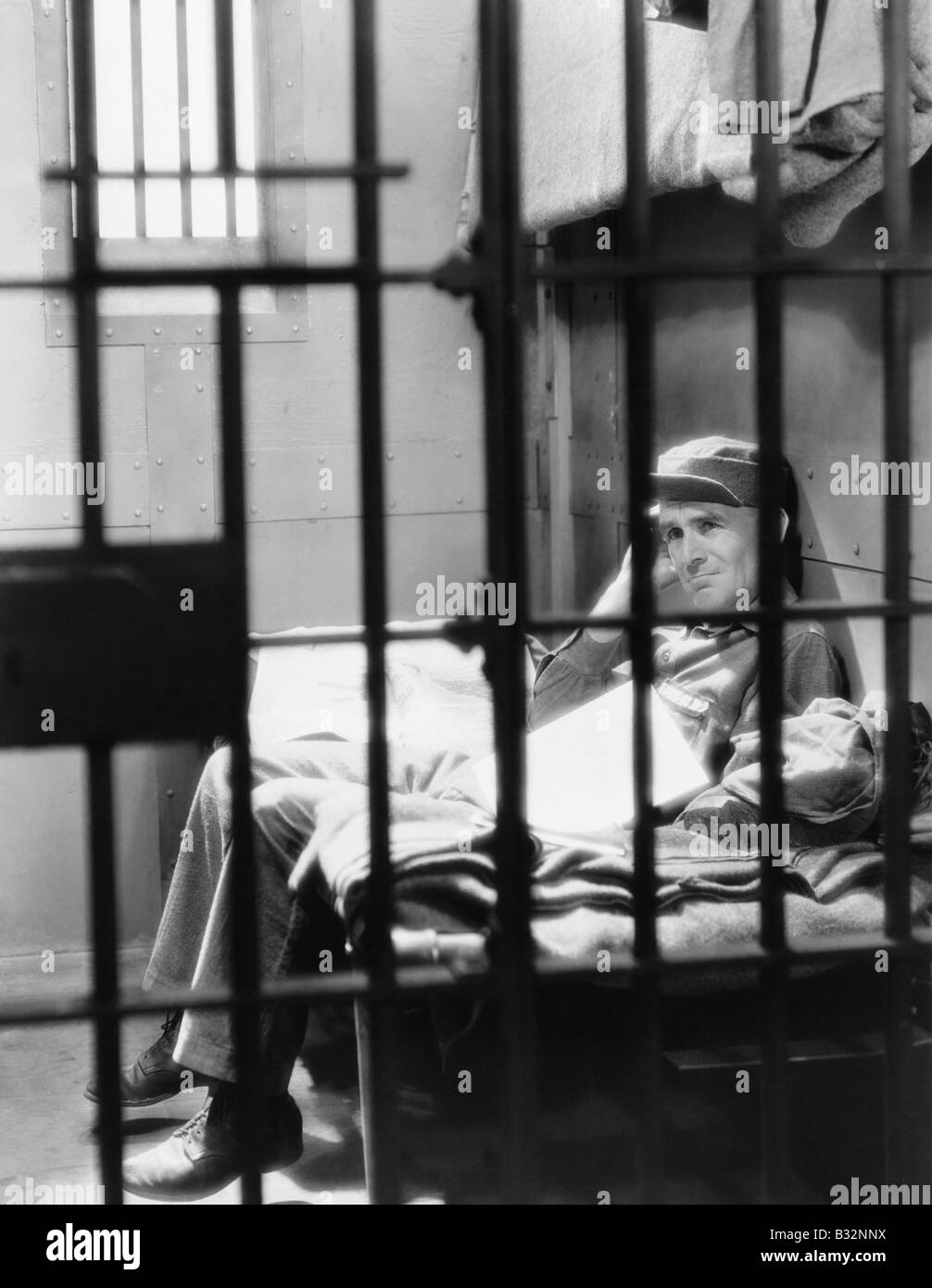 Prisoner sitting in prison cell Banque de photographies et d’images à ...